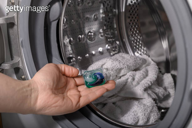 Laundry capsule put into the washing machine with a white towel 이미지 ...