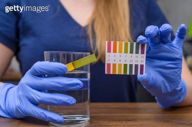 Chemical reaction of drinking water from a home tap, litmus paper ...
