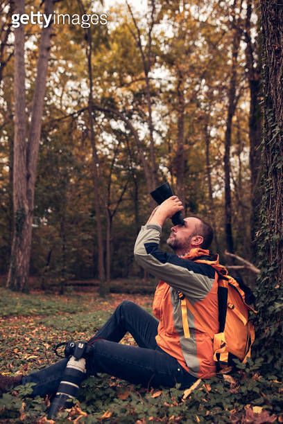 Man using binoculars and camera for bird and animal watching in nature ...