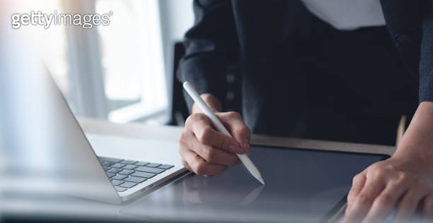 Businesswoman using stylus pen signing on digital tablet via mobile app ...