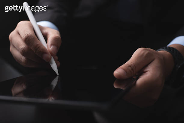 Business man hand using stylus pen touching on digital tablet screen ...