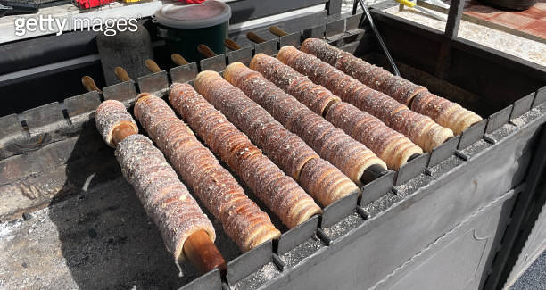 Trdelnik, traditional dessert baked in an open fire wooden stake in ...