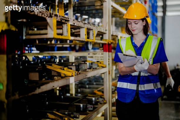 workers checking and inspecting metal machine part items for shipping ...