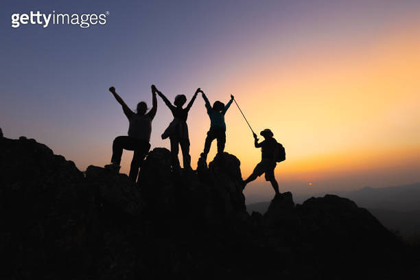 Silhouette Teamwork of four hiker helping each other on top of mountain ...