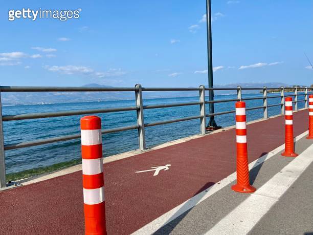Pedestrian walkway on a street by the waterfront separated by bollards ...
