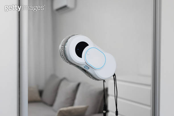 Robot washer vacuum cleaner that cleans a glass mirror in room. Robot ...