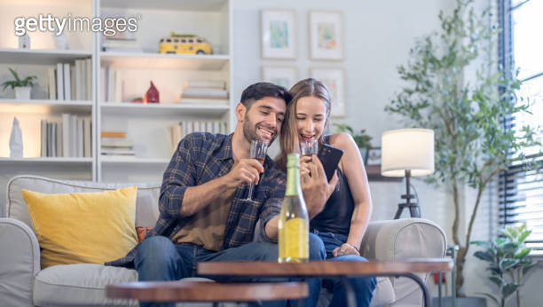 Diverse startup colleagues enjoy drinks, socializing in a relaxed ...