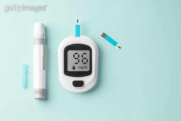 Glucometer, blood glucose sugar testing for diabetes on light green ...