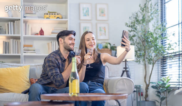 Diverse startup colleagues enjoy drinks, socializing in a relaxed ...