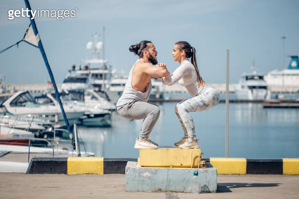 Female and male athlete is performing box jumps outdoor. (2151684630 ...