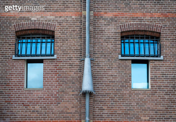 Exterior of an old prison building, brick wall and the windows with ...