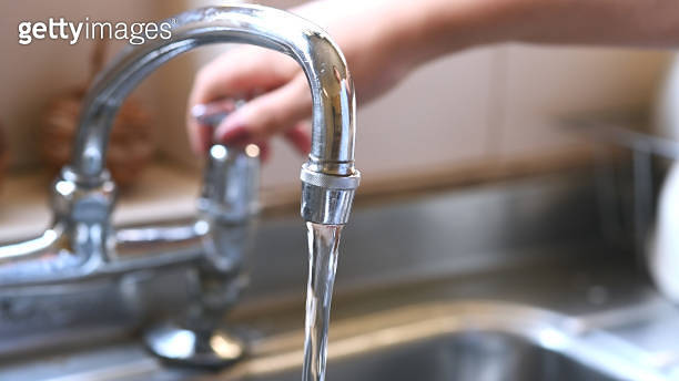 Open, water and faucet with hand of woman in kitchen for cleaning ...