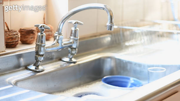 Faucet, cleaning and running water in the kitchen sink of a home for ...