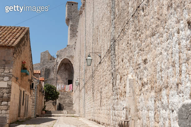 Inside wall of medieval city high wall leads to steps washing hanging ...