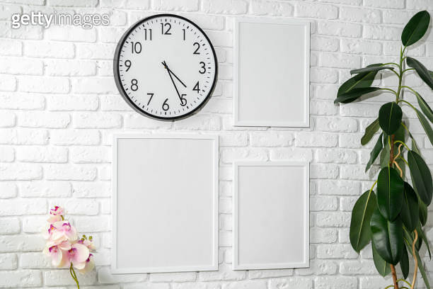Minimalist White Wall Display With Clock and Empty Frames in a Modern ...
