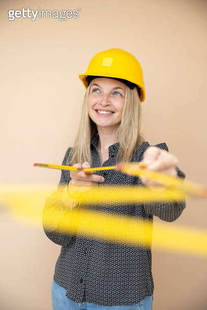 pretty young woman, architect, builder, technician with yellow work ...