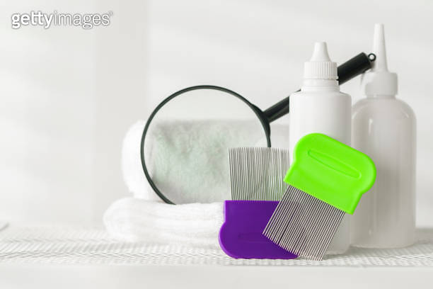 Lice treatment product next to a nit comb and magnifying glass 이미지 ...