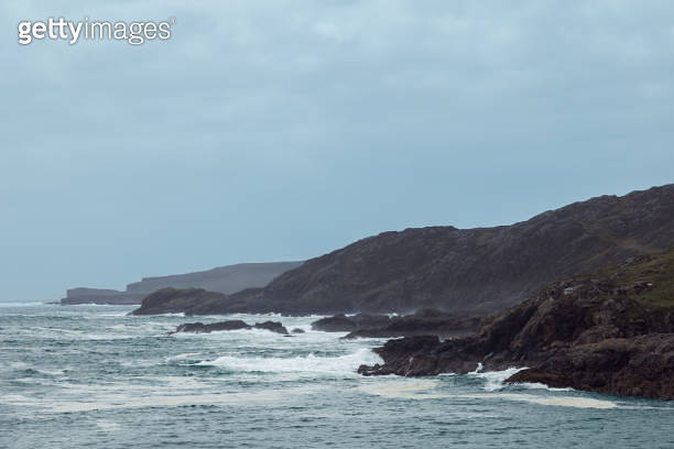 A moody view of Scourie Bay, where tumultuous waves crash against ...