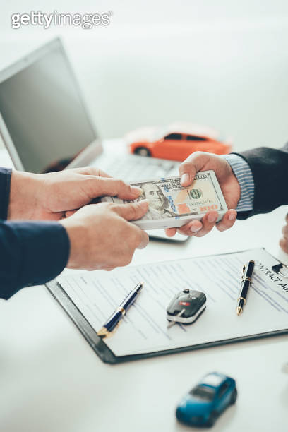 A salesperson is talking to a customer at a showroom with a low ...