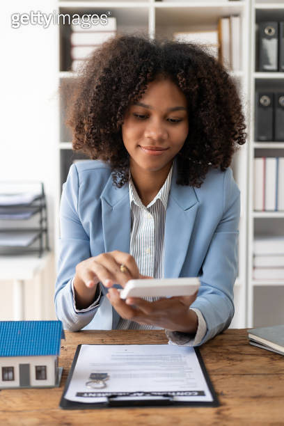 House model with real estate agent and client discussing home insurance ...