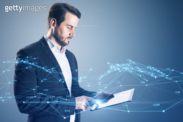 Attractive young european businessman using tablet with creative ...