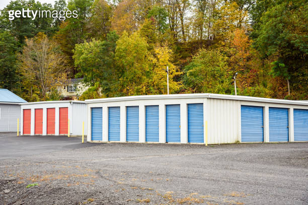 Rows of self storage units with colourful autumnal trees in background ...