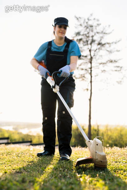 Woman with a weed whacker in outdoors 이미지 (2148722998) - 게티이미지뱅크