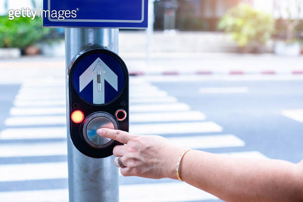 Close up pedestrian crossing call button. Hand pushing button to cross ...
