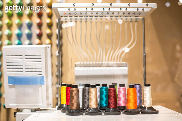 Selective focus to colorful sewing threads with blurry industrial ...