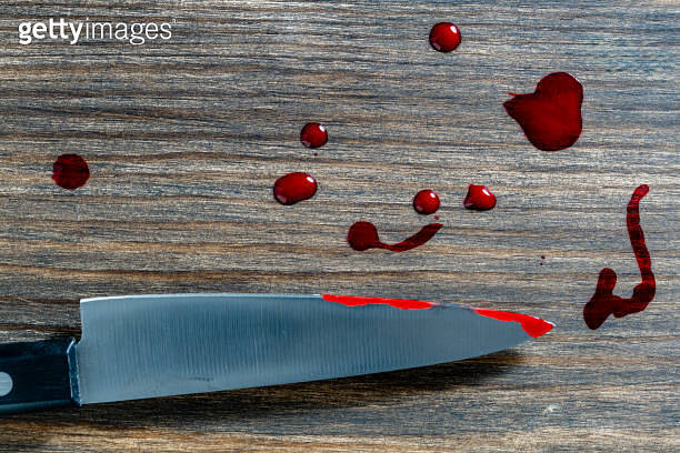 Kitchen knife with blood on the blade on the wooden table, closeup, top ...