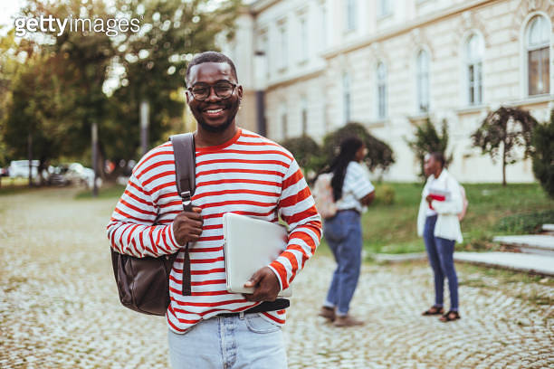 Happy university student going on a class at the university and looking ...