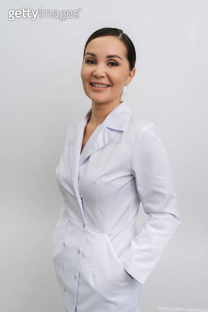 Vertical portrait of smiling female general practitioner wearing coat ...