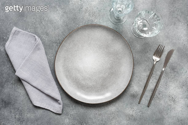 Table setting in gray color. Empty gray plate, cutlery and glasses on a ...