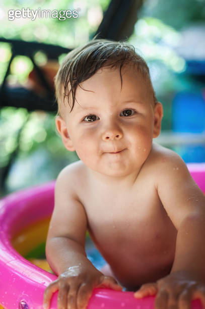 Baby boy is bathing in a little colorful wading pool 이미지 (2103684396 ...