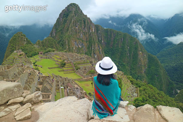 Visitor Sitting on the Cliff Being Impressed by the Inca ruins of Machu ...