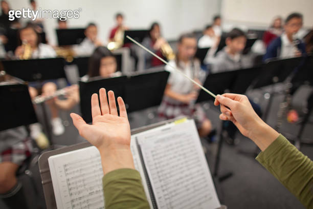 View of band instructor teacher conductor hands leading music ...