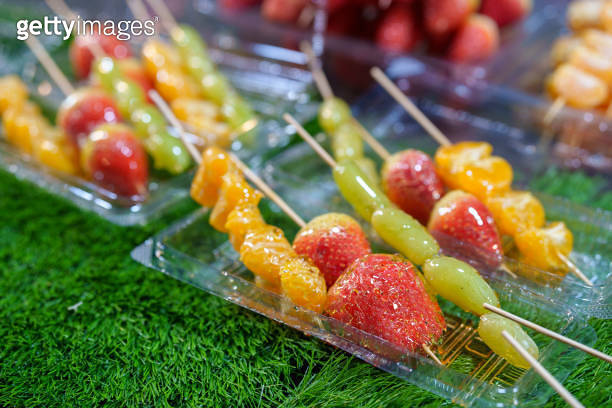 Sugar-coated fruit on a stick also known as “Tanghulu", popular street ...