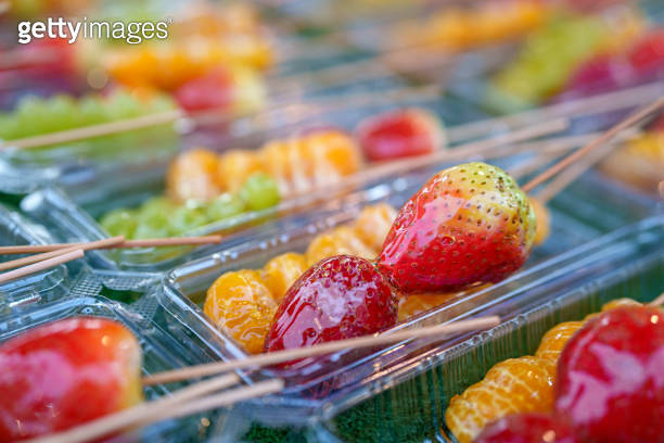Sugar-coated fruit on a stick also known as “Tanghulu", popular street ...
