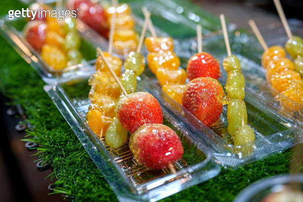 Sugar-coated fruit on a stick also known as “Tanghulu", popular street ...