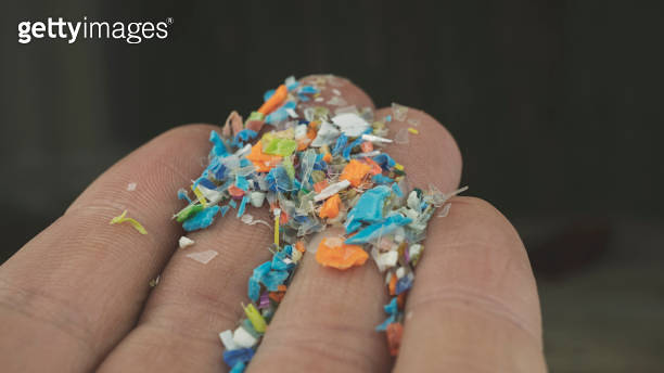 Close-up shot of microplastic particles in a human hand. Concept of ...