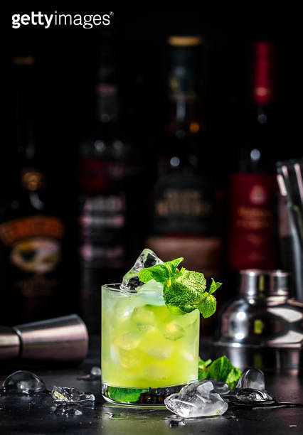 Green Negroni cocktail drink with gin, aperitif, liqueur, mint and ice ...
