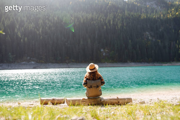 Adventure woman feeling happy among amazing mountains, forest and lake ...