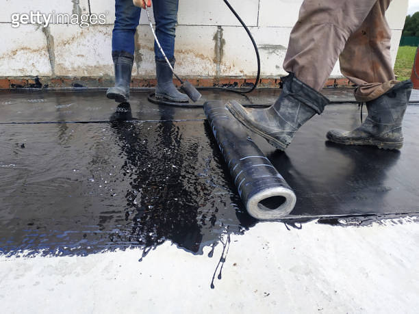 Worker covered surface, bitumen primer for improving adhesion during ...