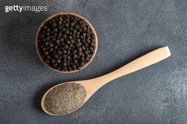 Ground black pepper on black background with black pepper grains ...