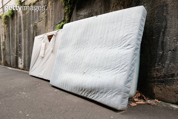 A discarded old bed base and mattress on the side of a road 이미지 ...
