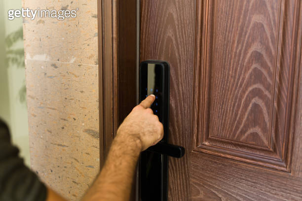 Man accessing his home using a smart lock system and entering a ...