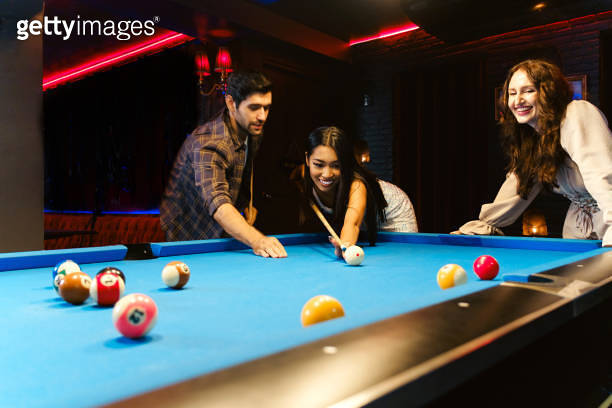 Young diversity group of people playing pool together with smile ...