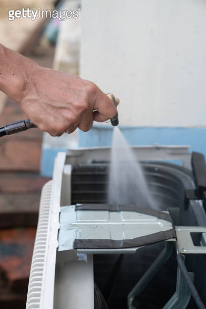 Engineer or repairman fixing and cleaning air conditioner unit by high ...