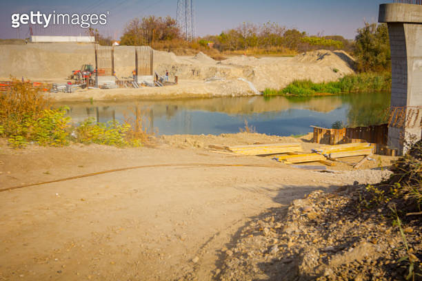 Bridge poles under construction over the river, works on building site ...