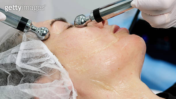 Beautiful woman receiving facial microcurrent treatment at spa salon ...